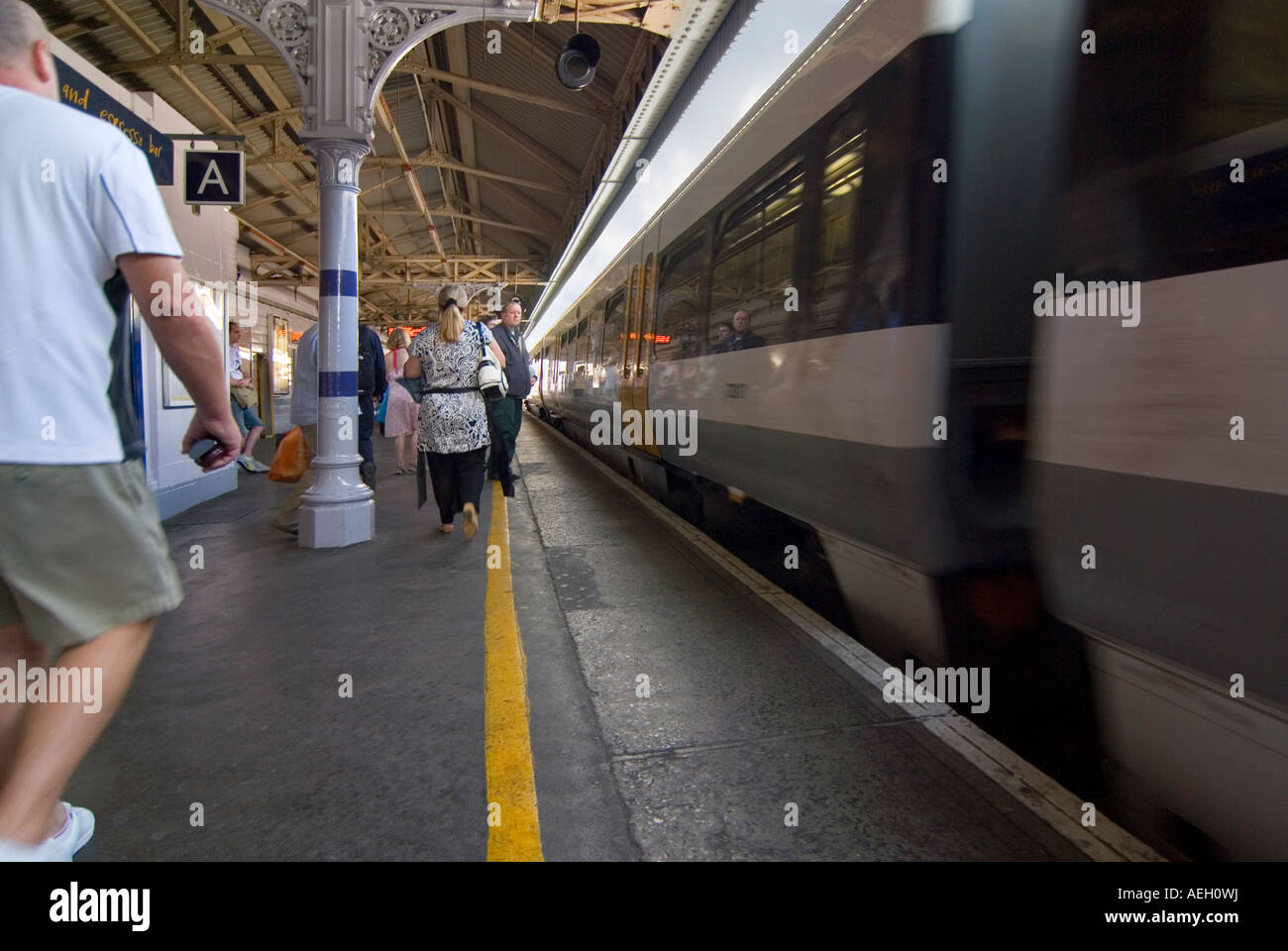 Horizontal wide angle of people rushing to catch a train arriving at ...