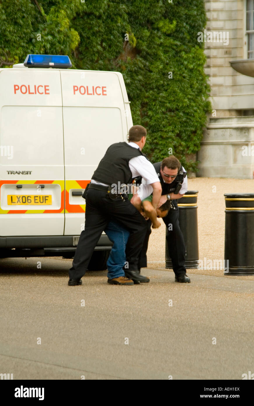 Vertical close up of a man fighting with police as he resists arrest in ...