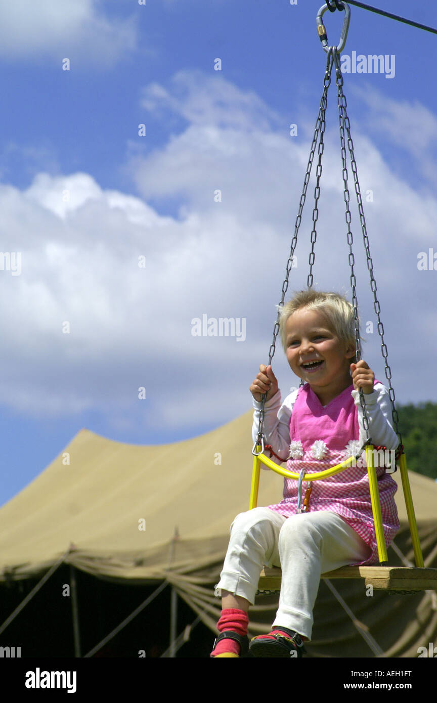 One small young girl child kid sitting happy in ropeway harness ...