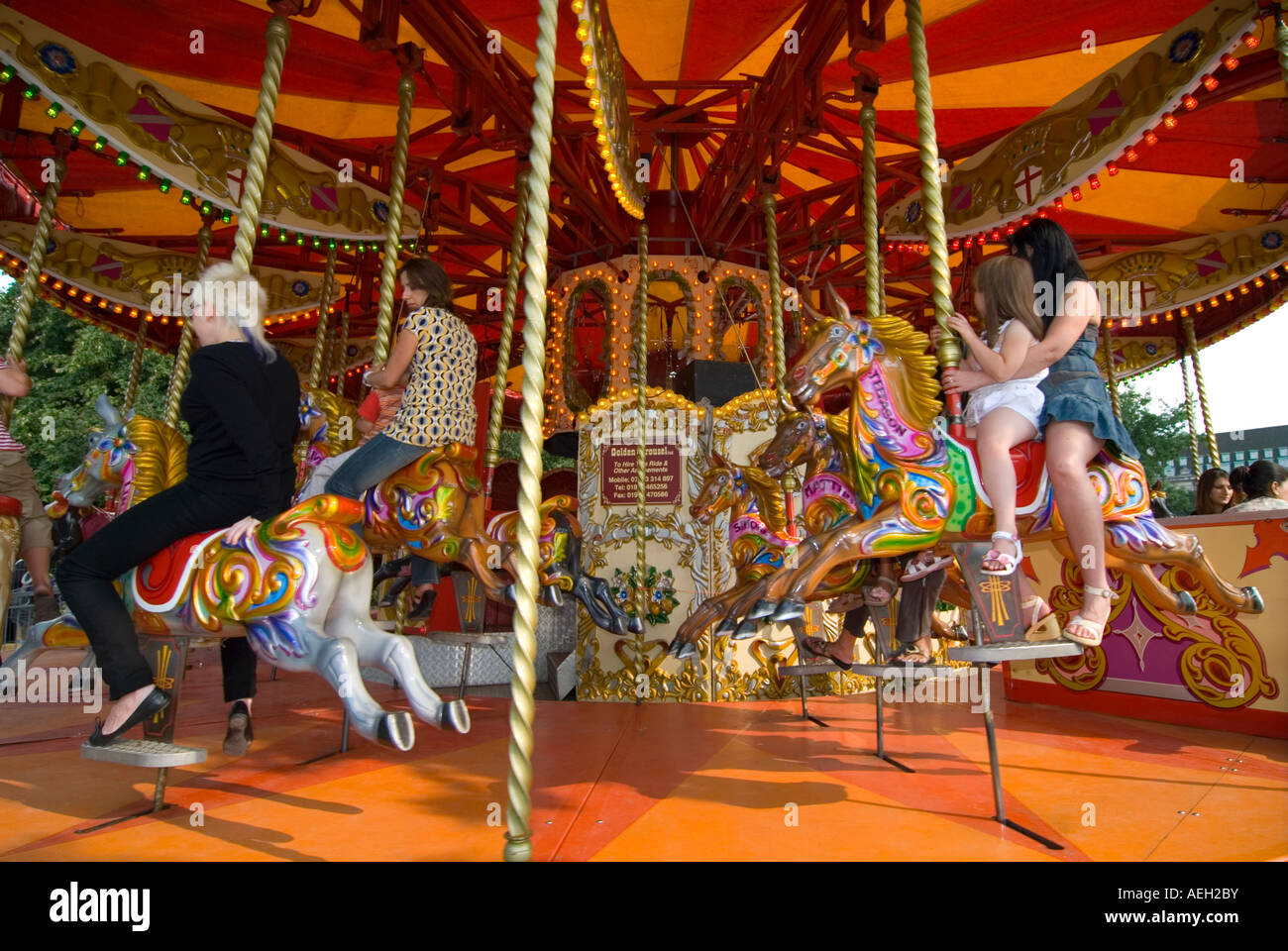 Horizontal wide angle of a colourful old fashioned merry go round with ...