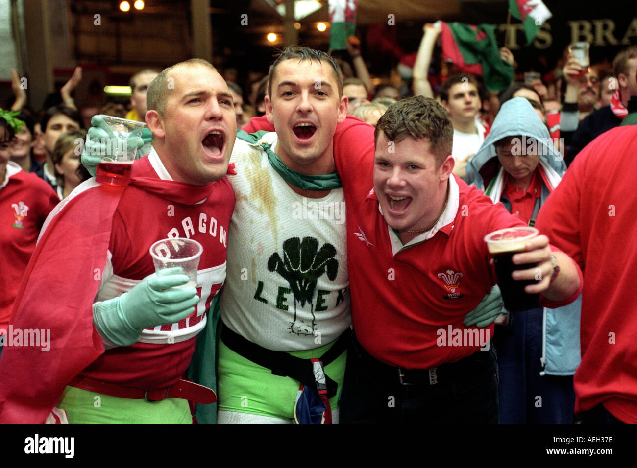 Welsh rugby fans in fancy dress singing and drinking beer on streets of ...