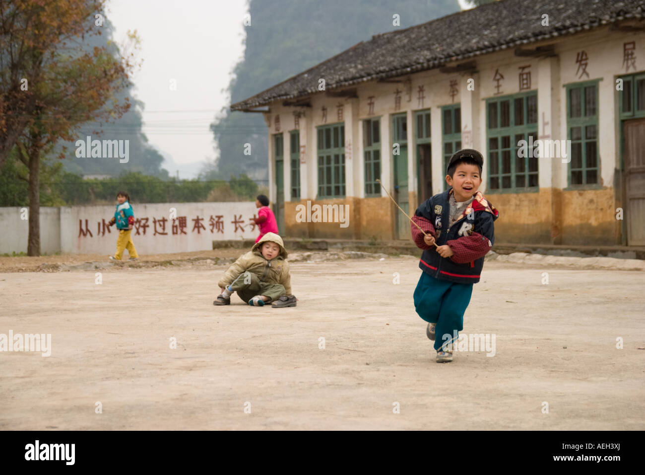 Child running in schoolyard in China Yangshuo Stock Photo - Alamy