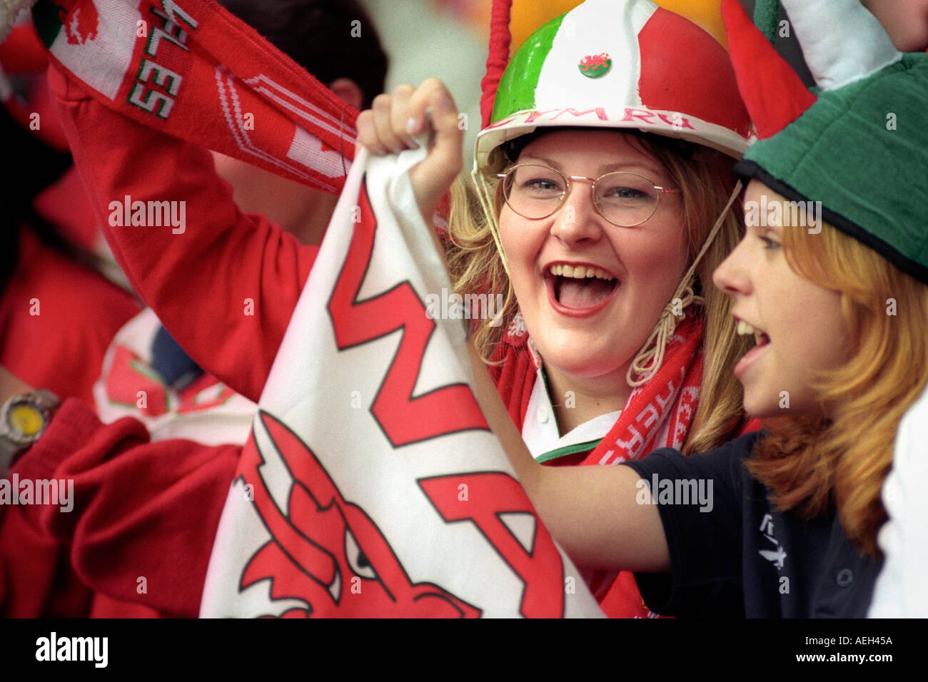 Young women Welsh rugby fans cheer on the team at a Wales international ...