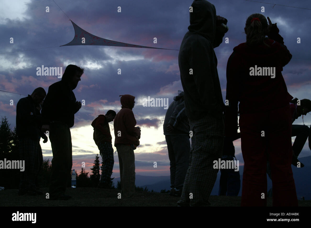Young people boy girl teen silhouette dancing outdoors evening at rave ...