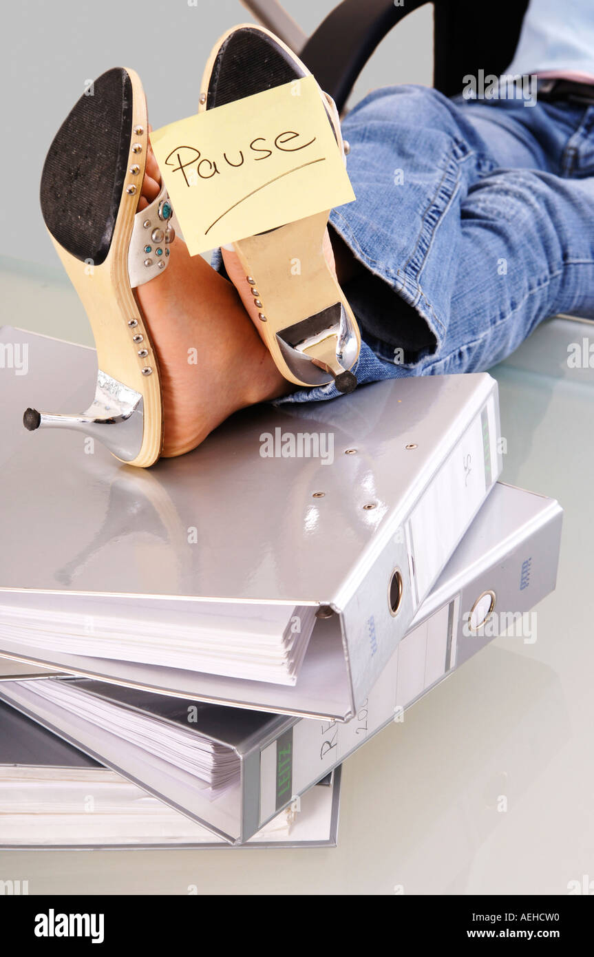 Woman at work with feet up on files Stock Photo - Alamy