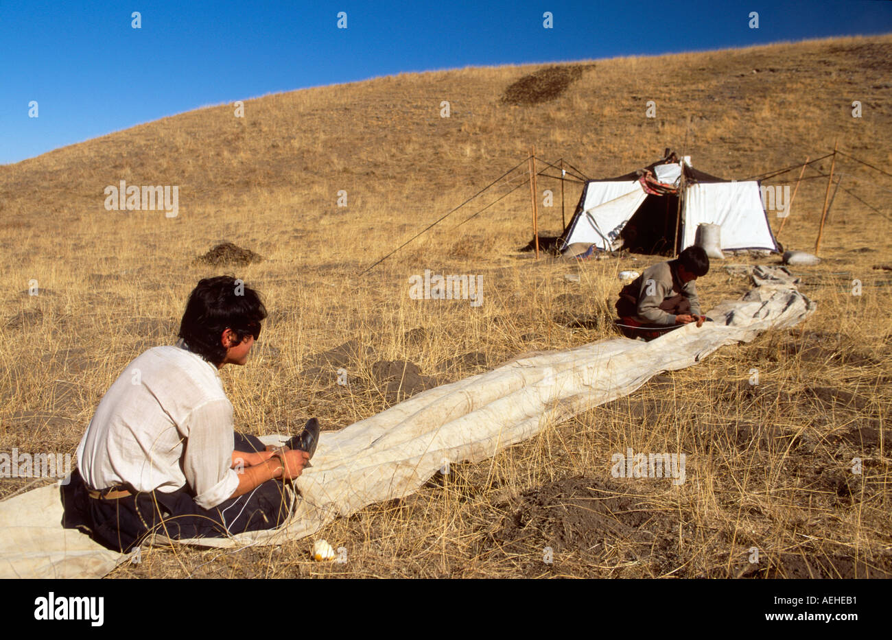 Tibetan nomads mending cloth in front of their Yak-wool tent on the ...