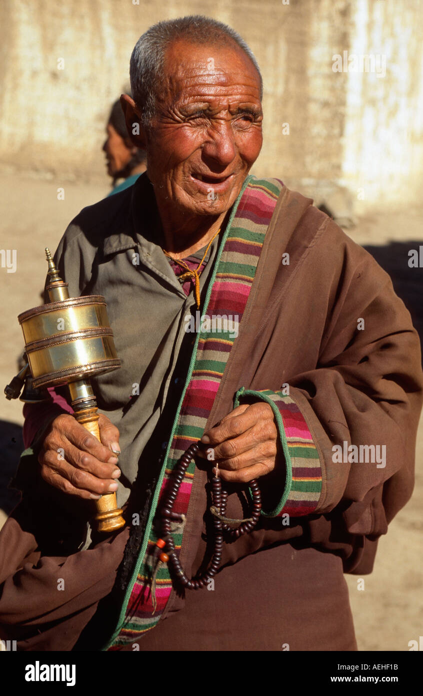 Old Tibetan nomad pilgrim with prayer wheel at the Amchog Gonpa ...