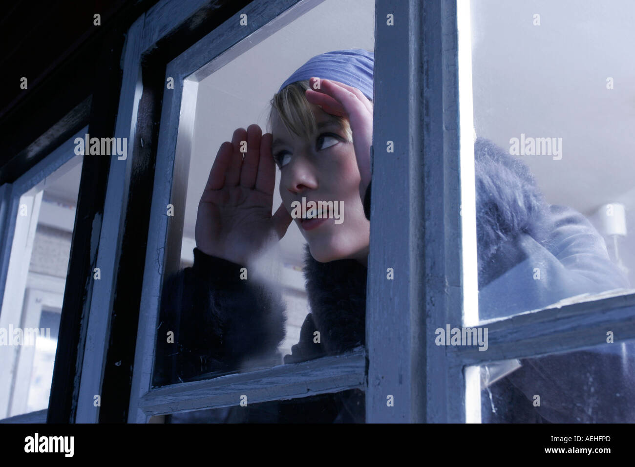 Woman looking through window Stock Photo - Alamy