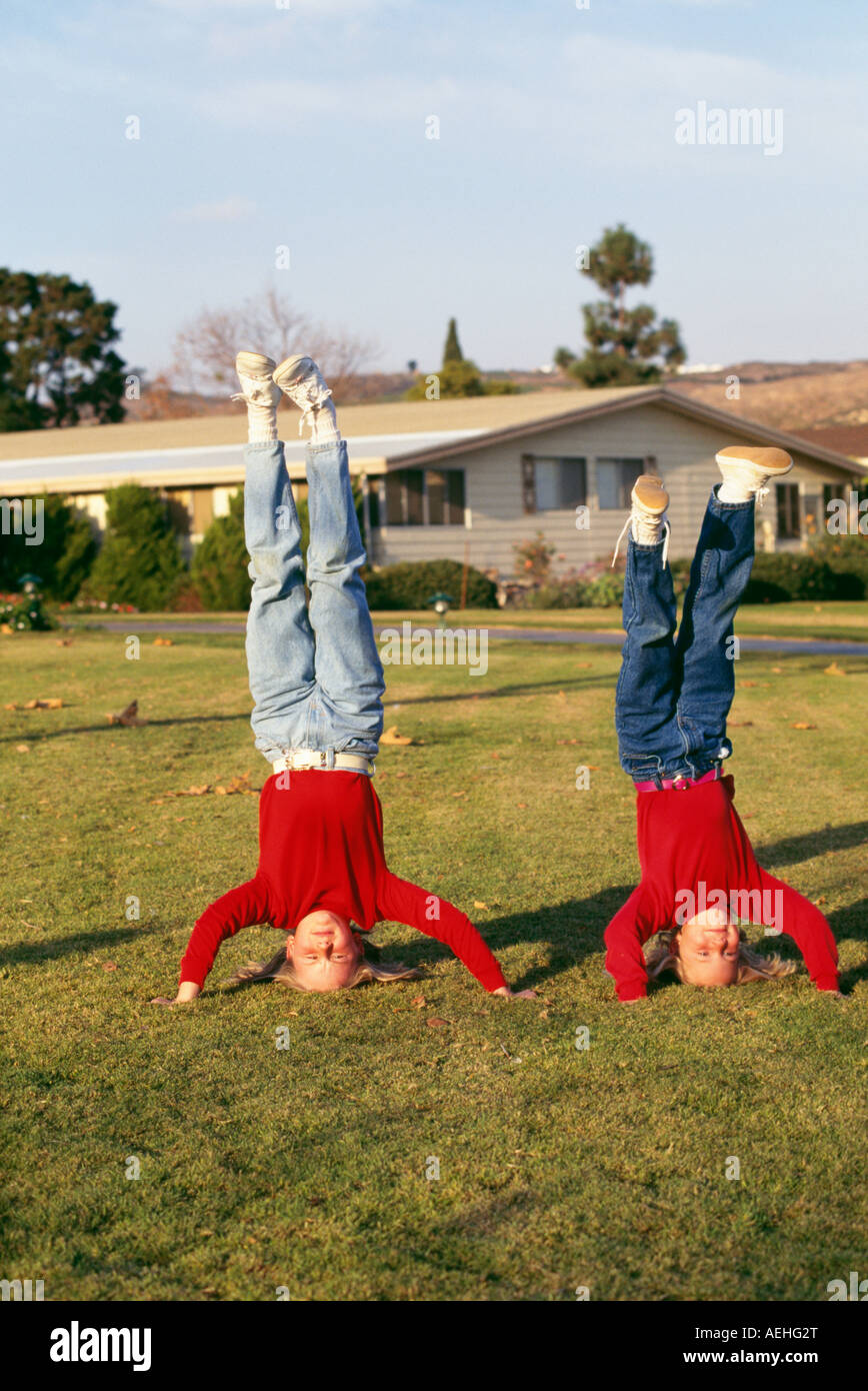 Brother and sister balancing upside down Stock Photo - Alamy