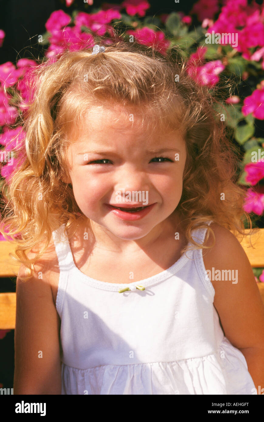 Girl smiling with flowers in background Stock Photo - Alamy