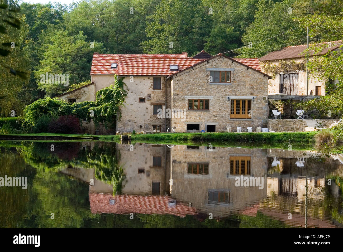 Mill house reflected in Lake in central France Stock Photo - Alamy
