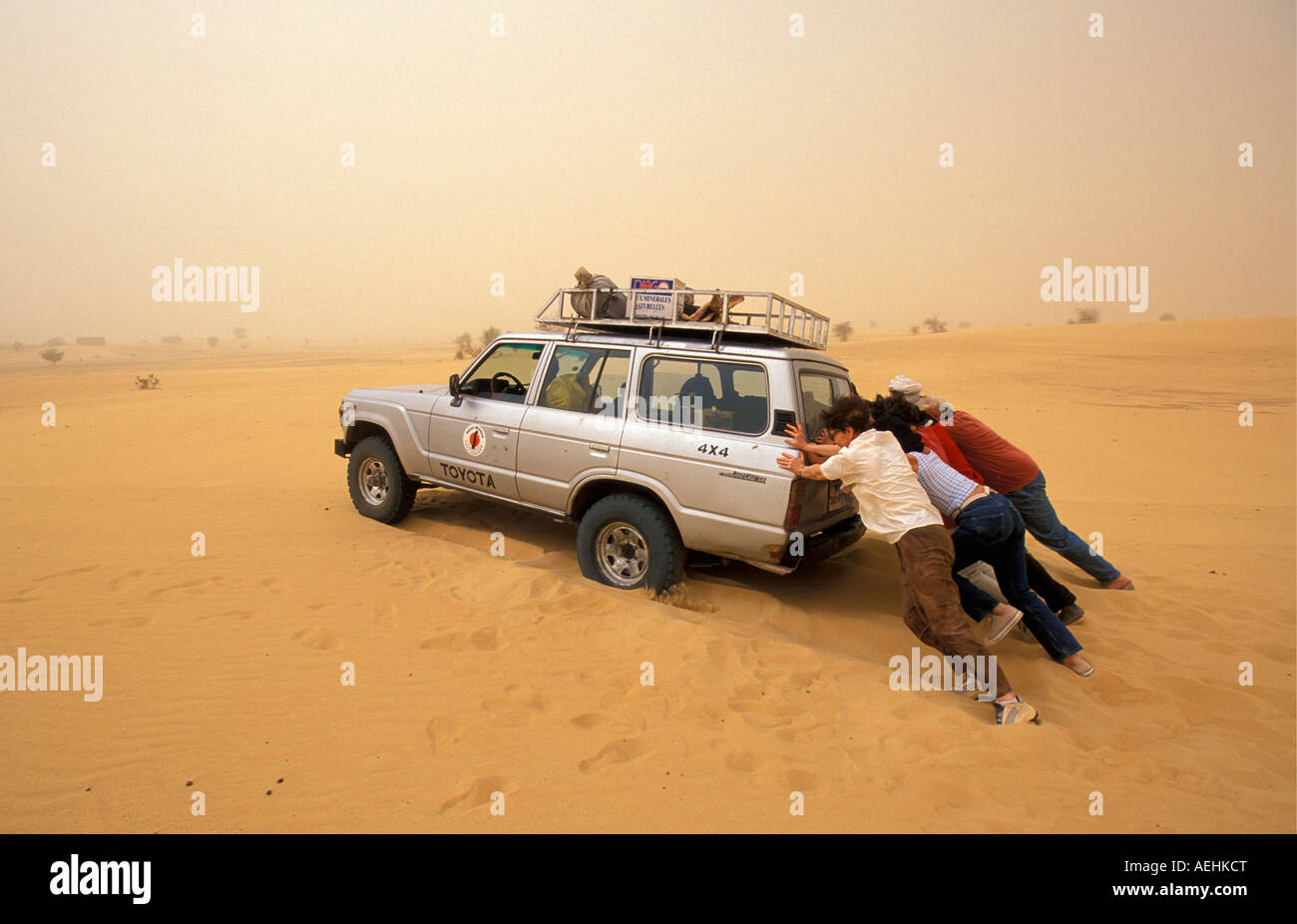 Mali Bamba, Tourists pushing 4x4 car in sandstorm Stock Photo - Alamy