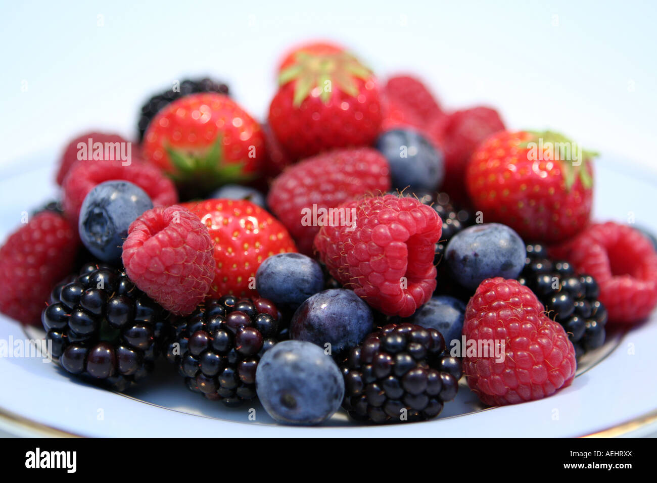 Mixed berries on a plate an eye level close up landscape view with a ...