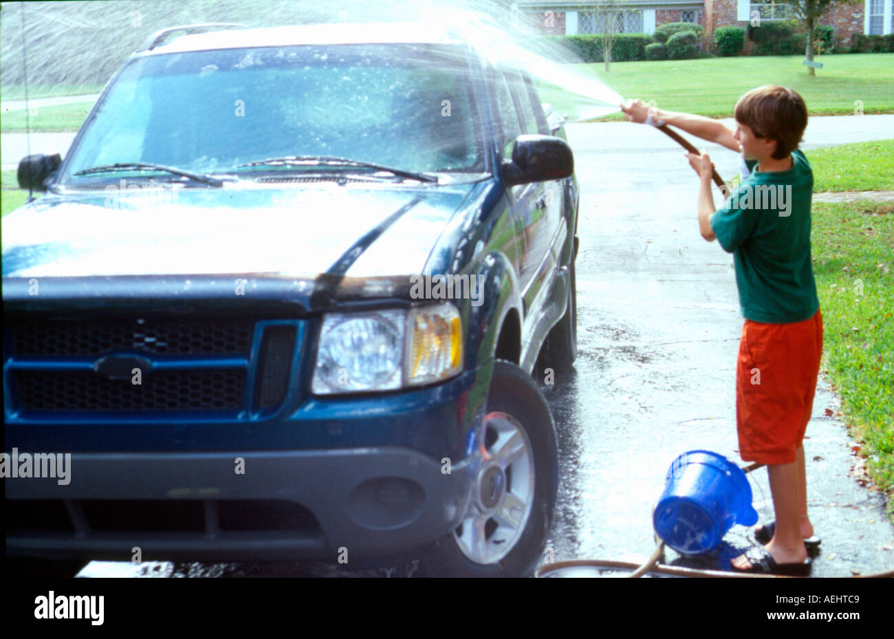 Teenage boy washing car in driveway Stock Photo - Alamy