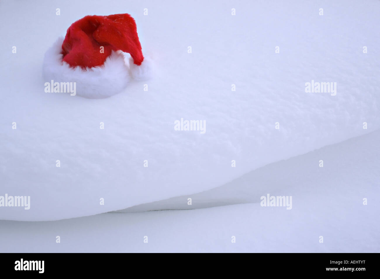 Santa hat n a snow drift Stock Photo - Alamy