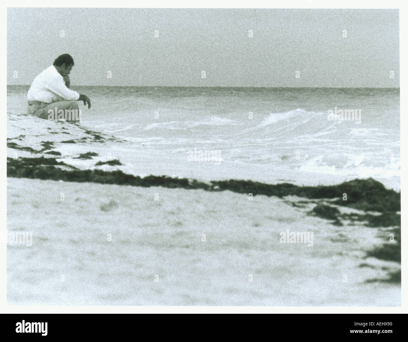 Man sitting on the beach thinking Stock Photo - Alamy