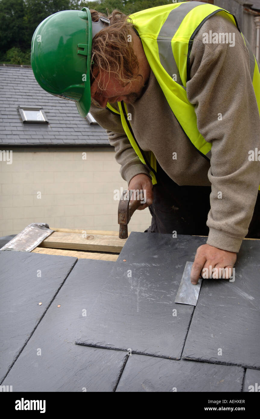 A ROOFER FIXING THE RIDGE ON A SLATE ROOF UK Stock Photo - Alamy