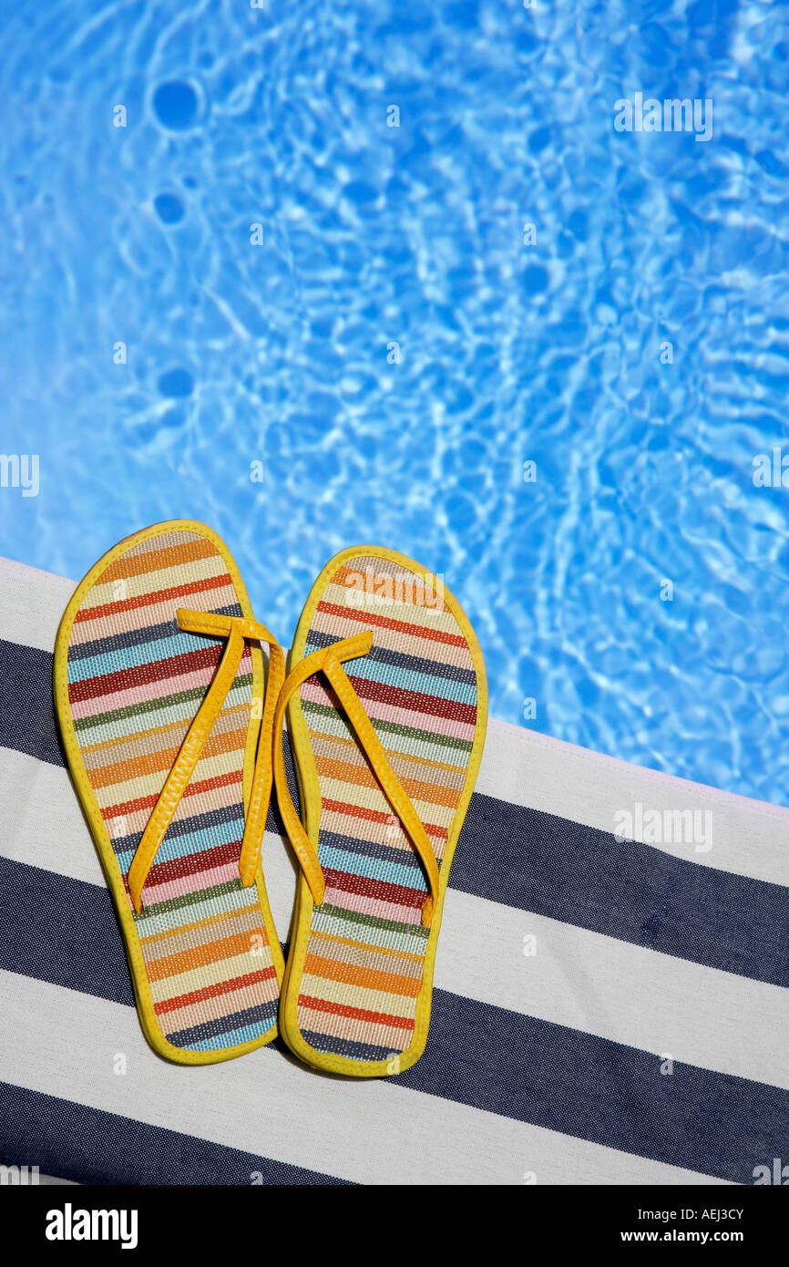 Shoes by bright blue pool in the summer Stock Photo - Alamy