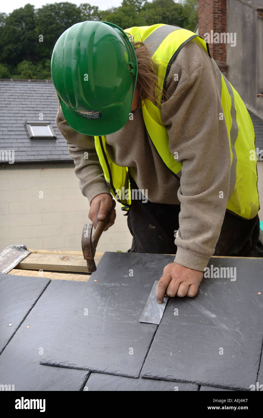 A ROOFER FIXING THE RIDGE ON A SLATE ROOF UK Stock Photo - Alamy