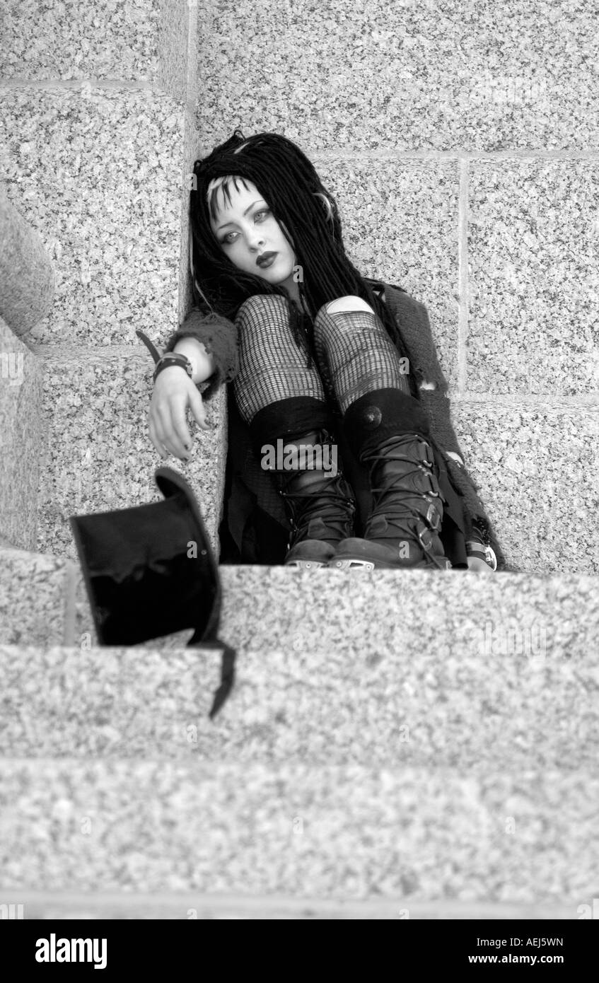A goth sitting on granite steps with a tophat Stock Photo - Alamy