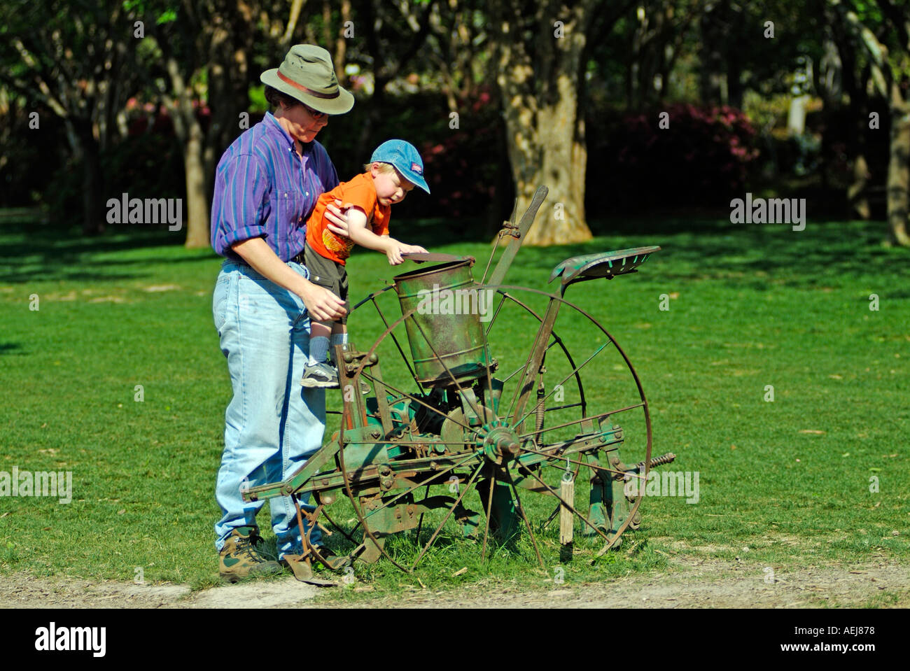 Young boy learning how to use an old metal plow Stock Photo - Alamy