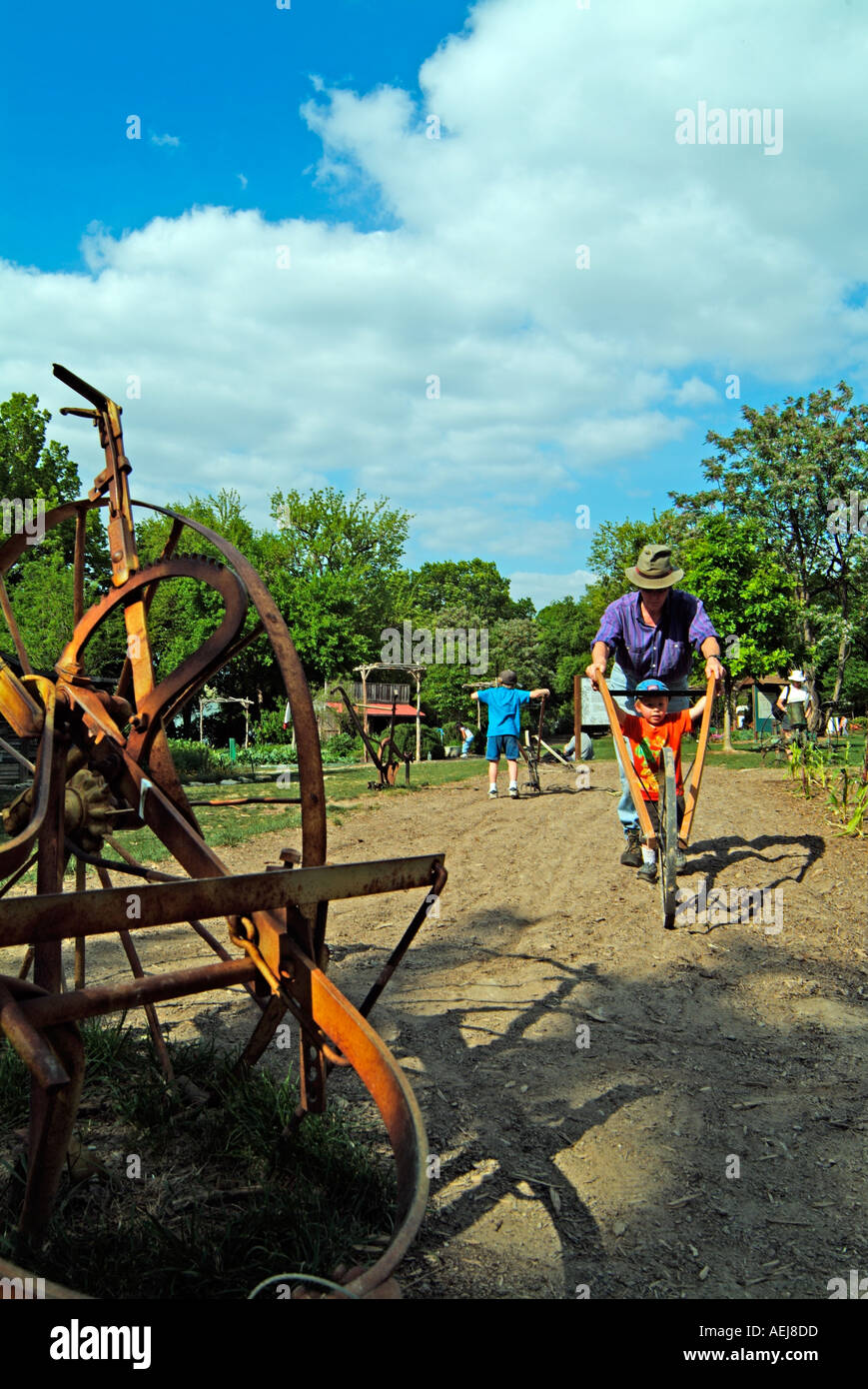 Young boy learning how to use an old metal plow Stock Photo - Alamy