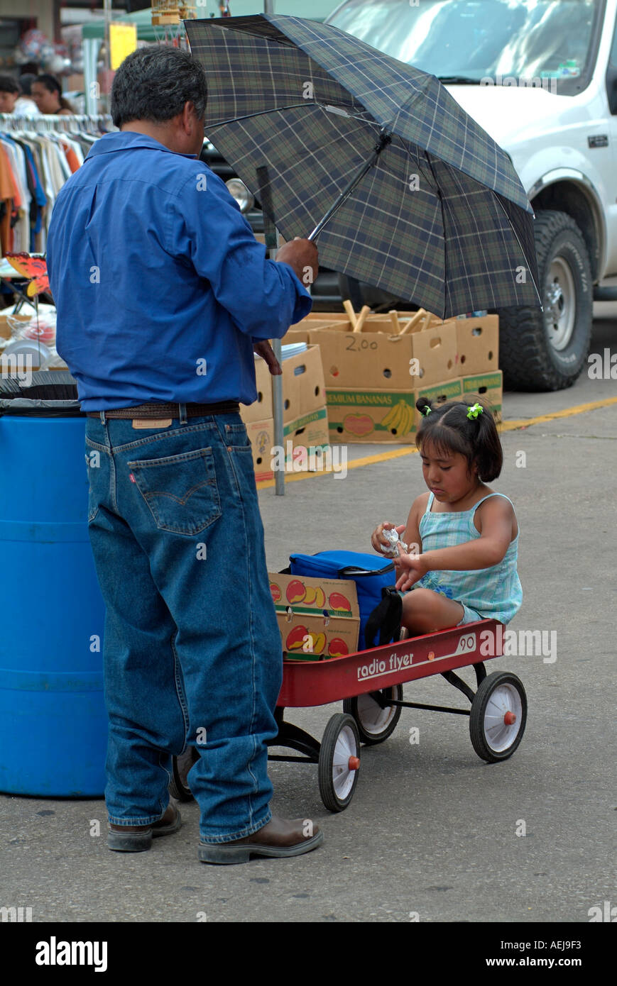 Man protecting her daughter with an umbrella Stock Photo - Alamy