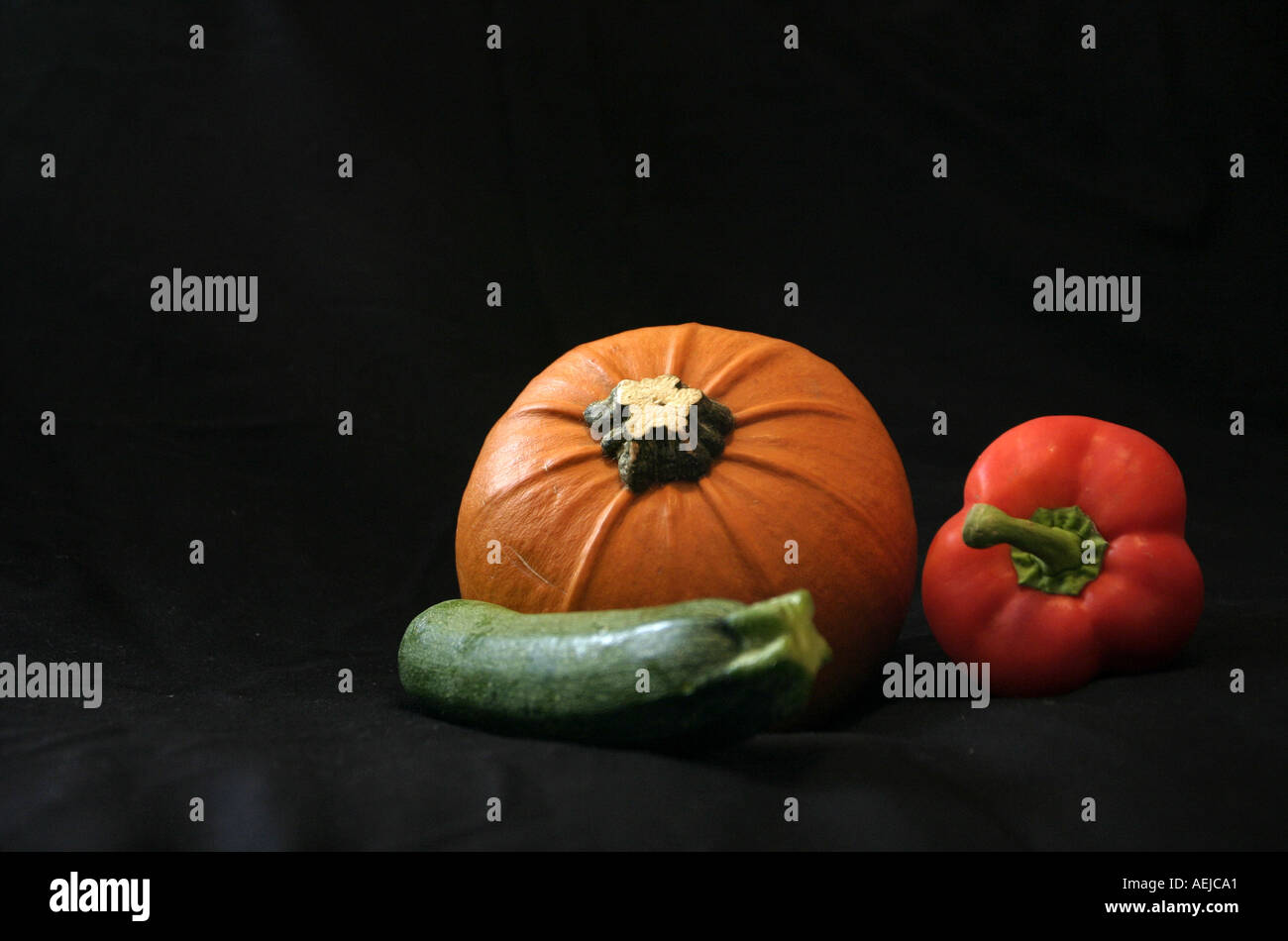 pumpkin red pepper and courgette in black background Stock Photo - Alamy