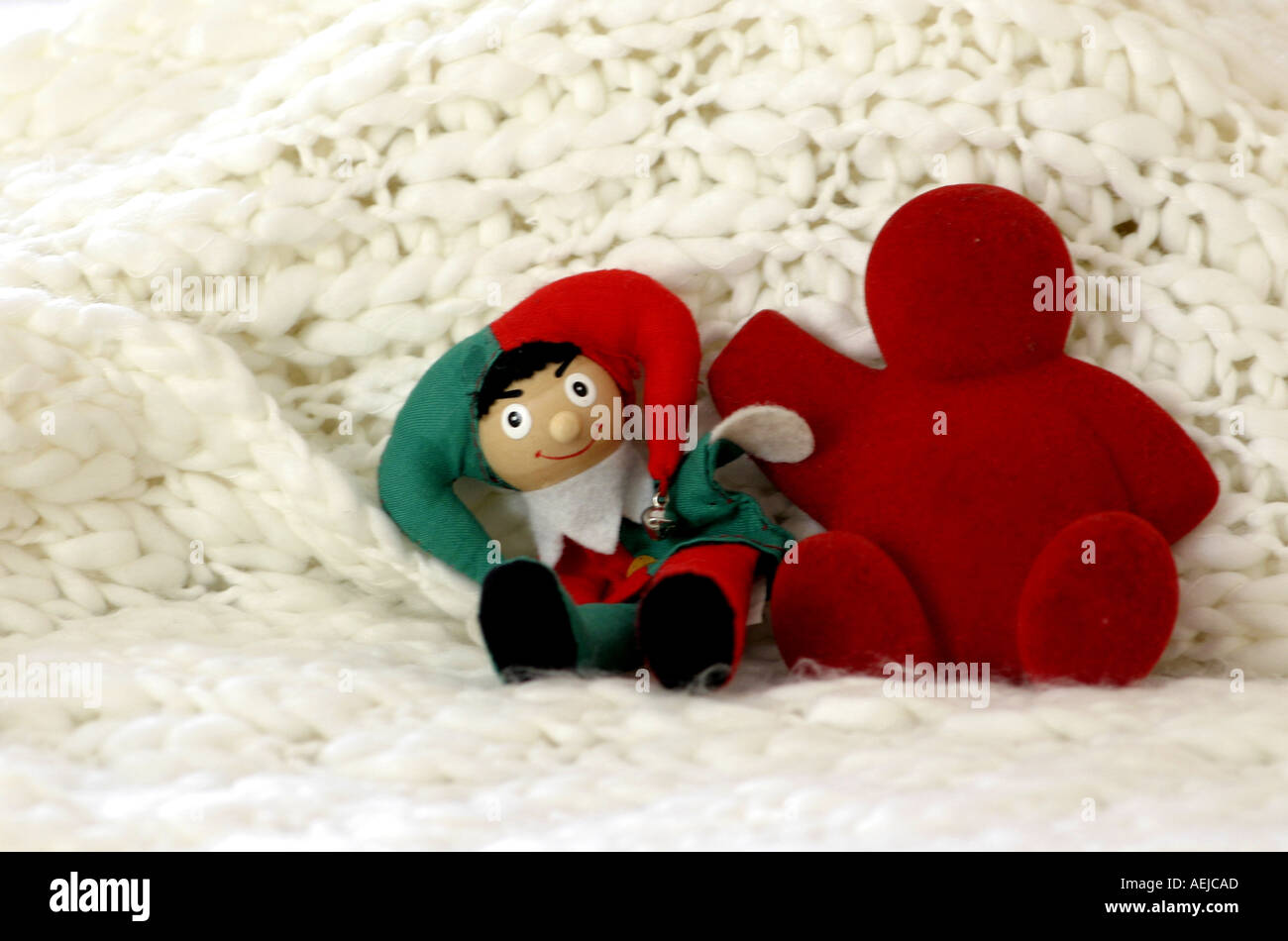 Red puppet and red and green puppet sitting on white fabric Stock Photo ...