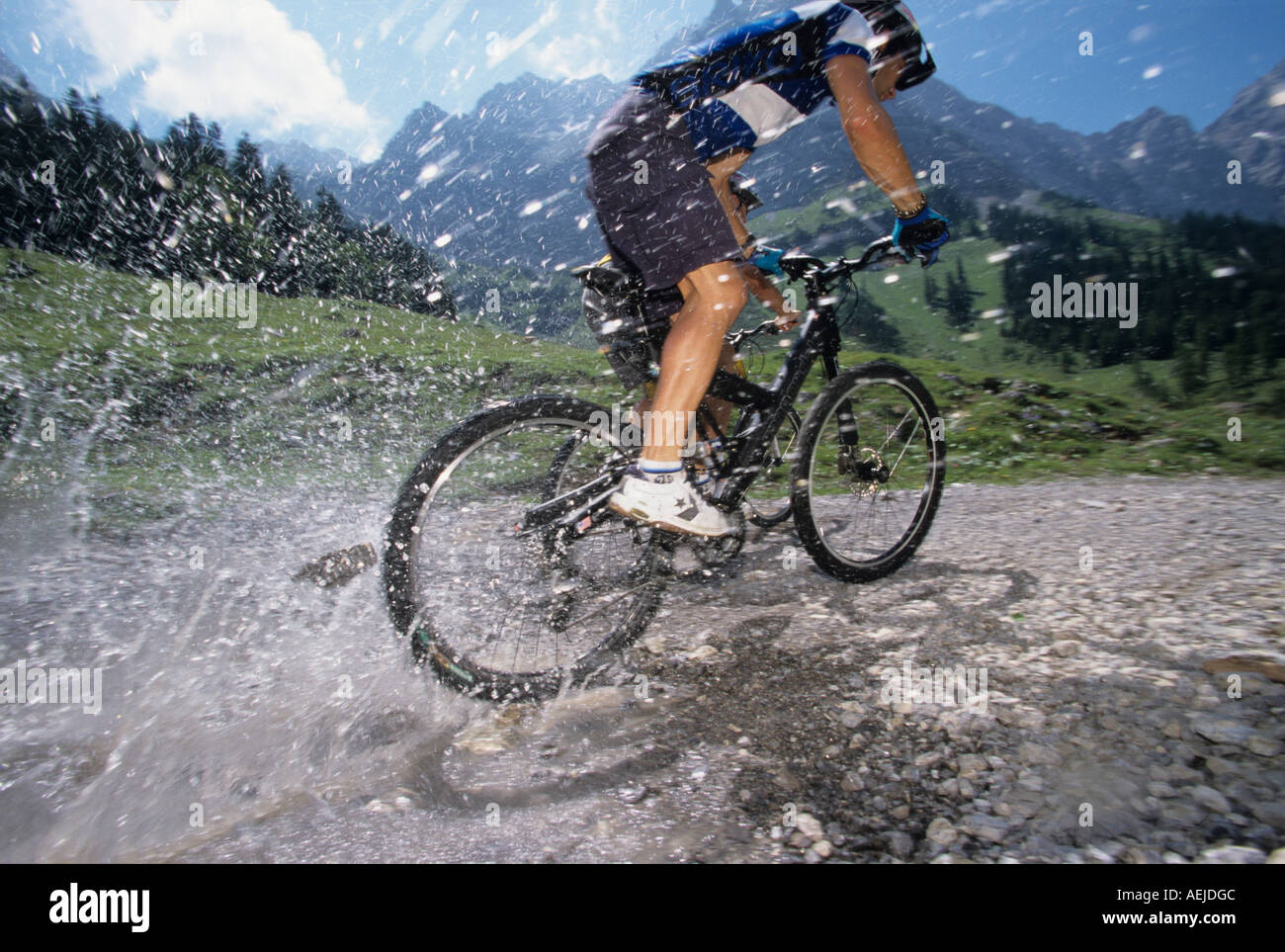 Man cycling in puddle, side view Stock Photo - Alamy