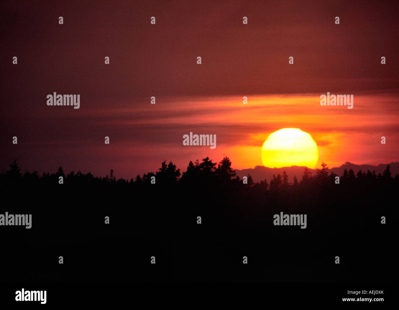 sunset or setting sun over a distant hill or mountain Stock Photo - Alamy