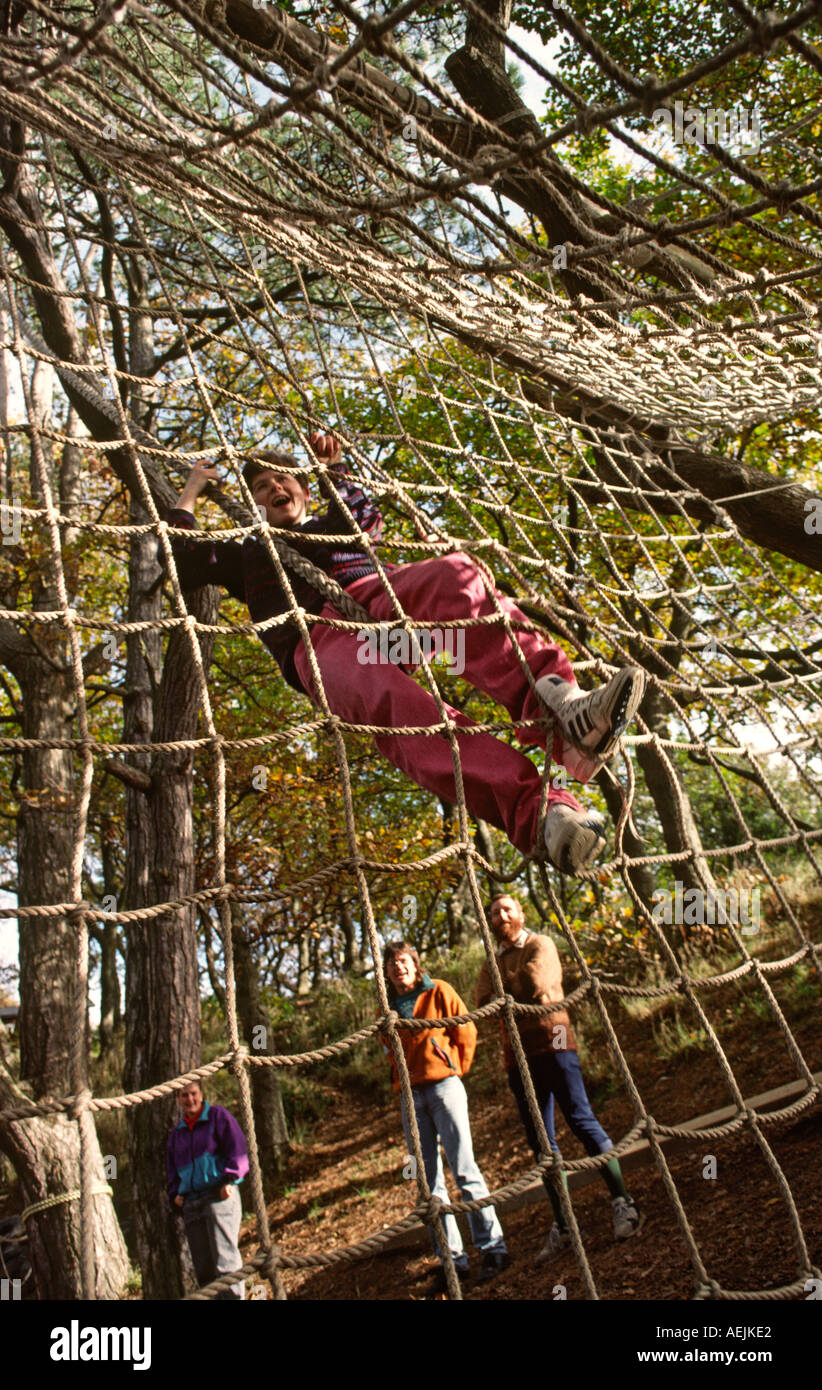 Outward Bound children on rope swing and net over water Stock Photo - Alamy