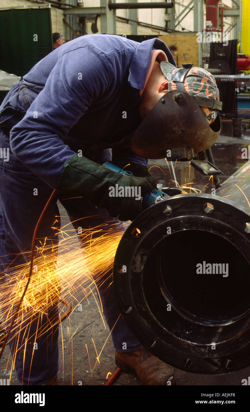 Industry Man grinding pipework Stock Photo - Alamy