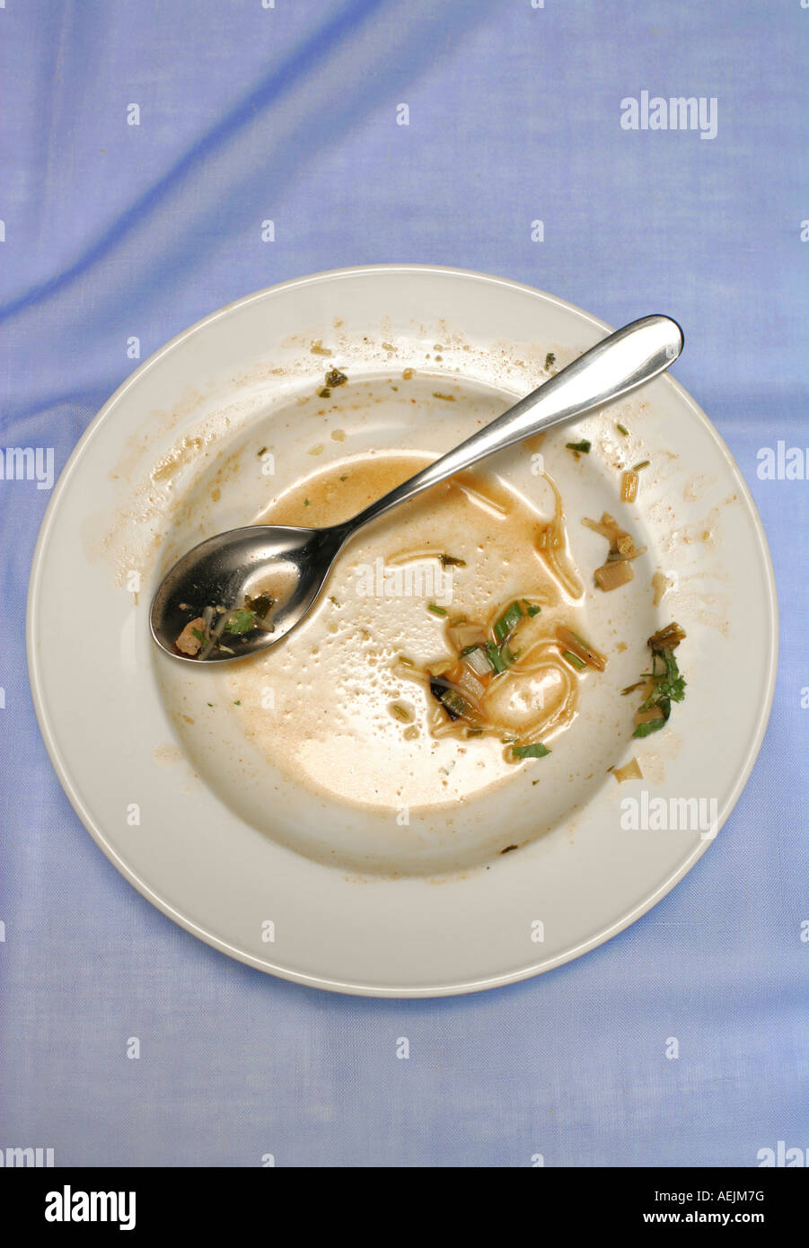Plate with spoon and leftovers of vegetable soup Stock Photo - Alamy