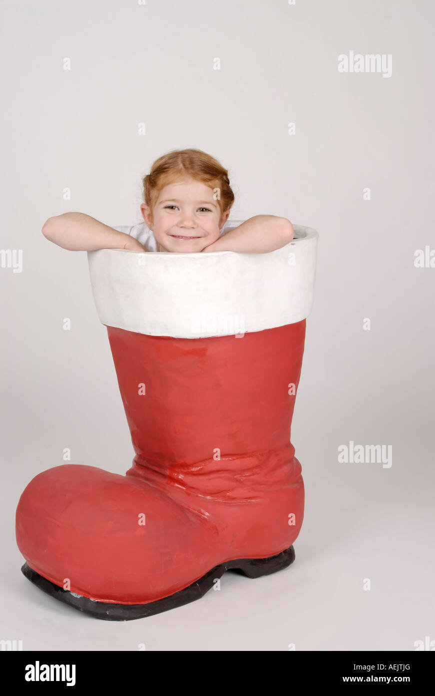 Little girl in a huge Santa Claus boot Stock Photo - Alamy