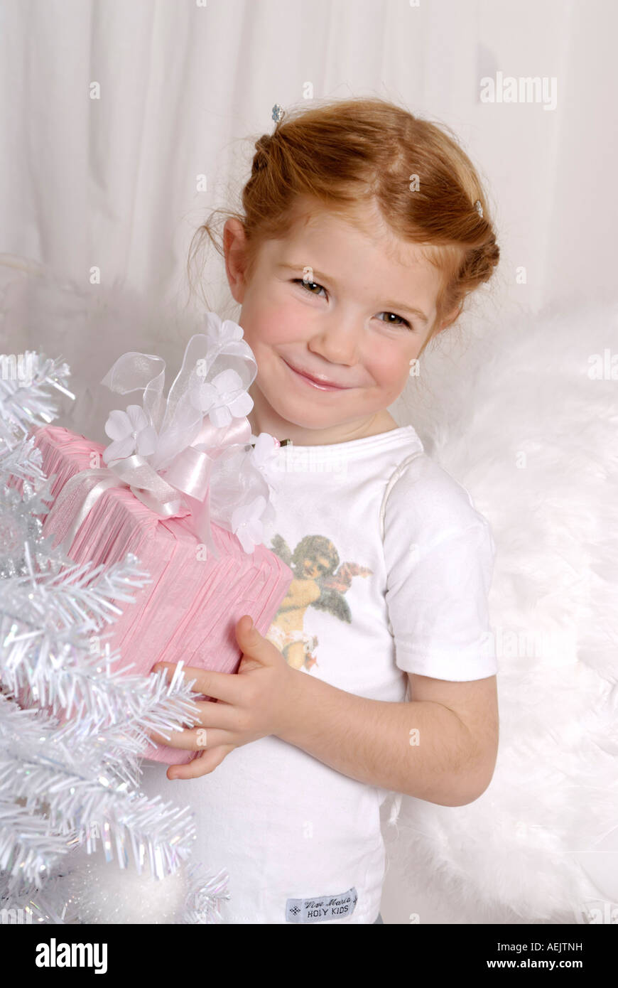 Little christmas angel with a christmas present Stock Photo - Alamy