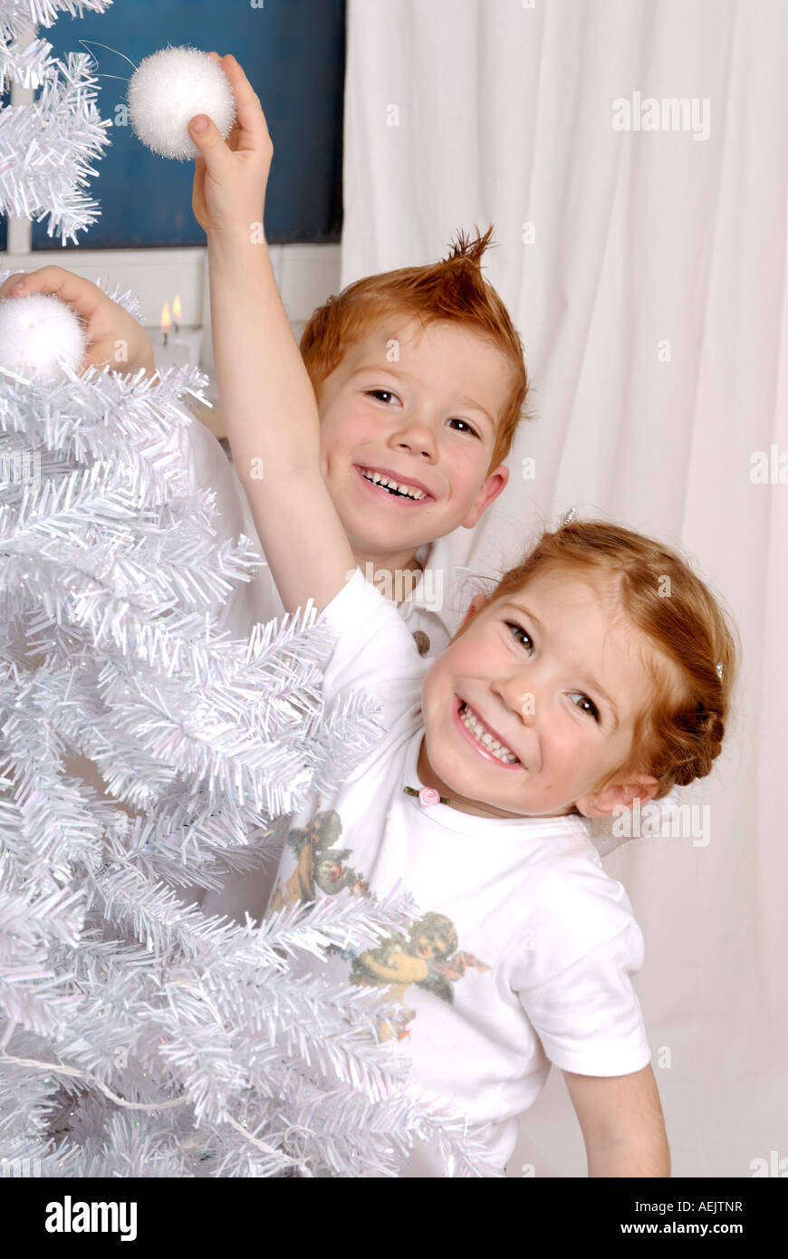 Two children are decorating a christmas tree Stock Photo - Alamy