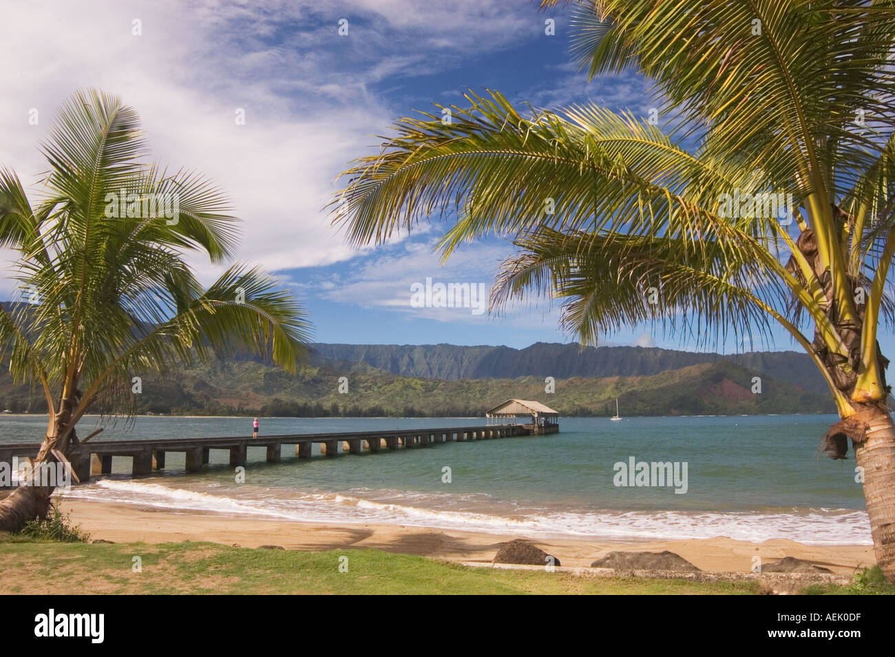 Hanalei Bay Kauai Hawaii with man on pier and sailboat anchored in bay ...