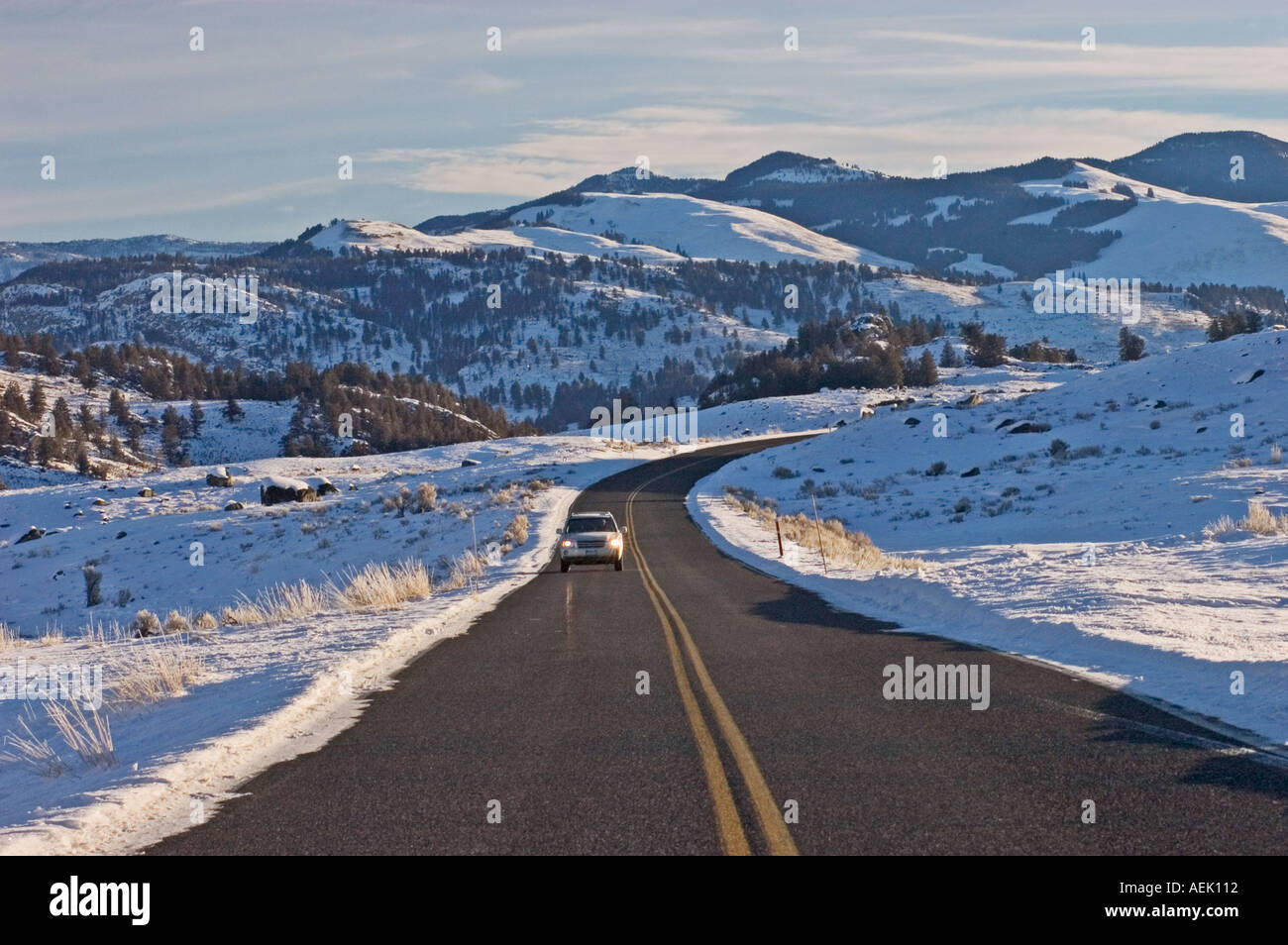 Car driving on Hwy 212 through Lamar Valley on an early winter morning ...