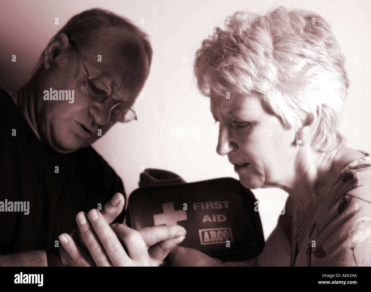 Woman helps man with finger injury and first aid box Stock Photo - Alamy