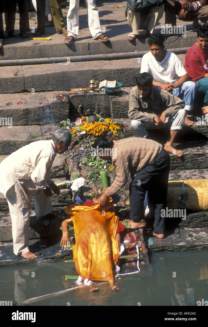A corpse is ritually washed before its cremation at the sacred site of ...