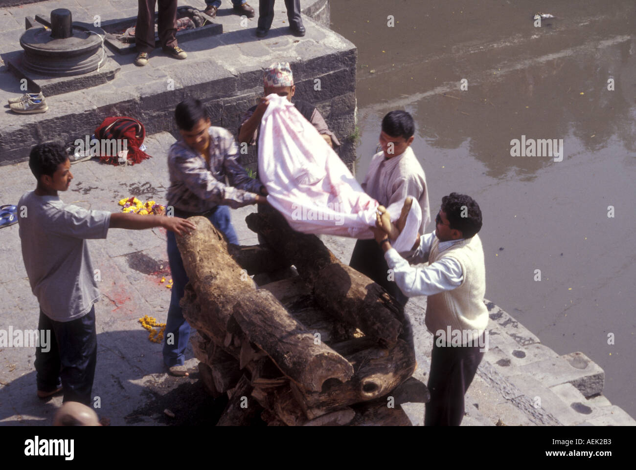 HINDUISM relatives loading a body for cremation on a funeral pyre in ...