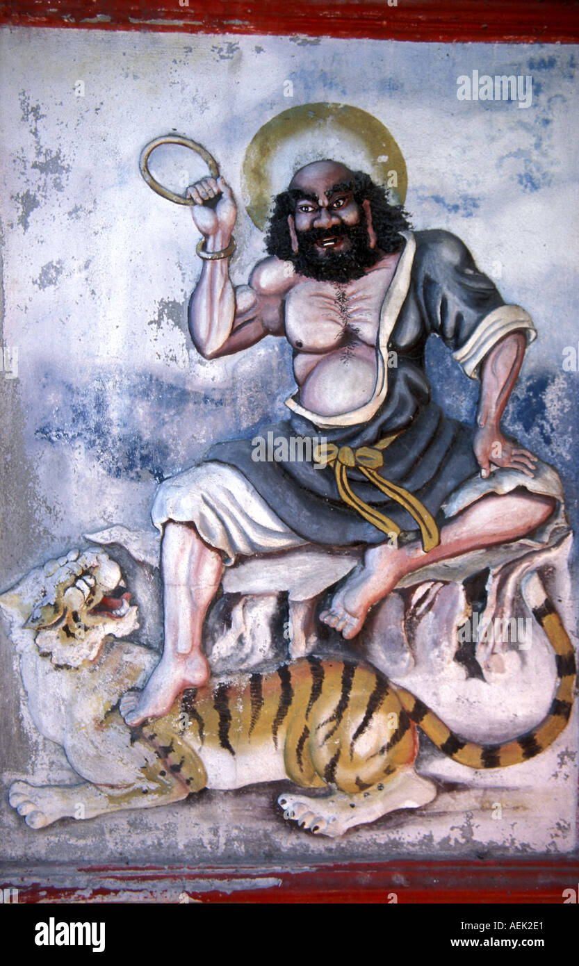 Taoist temple mural of a demon with his foot on a snarling tiger Stock ...