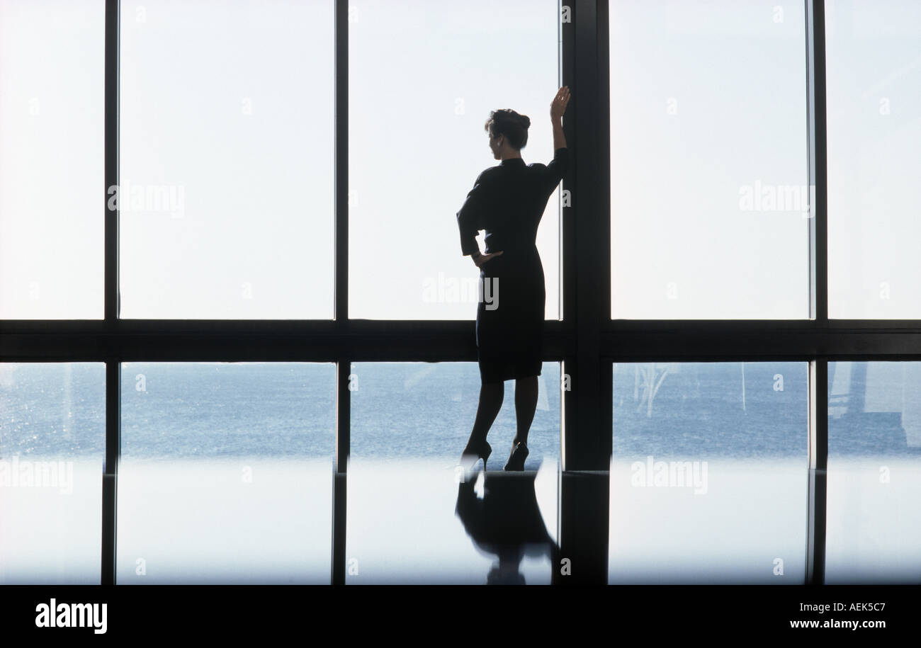 Silhouette of female executive contemplating at board room window Stock ...