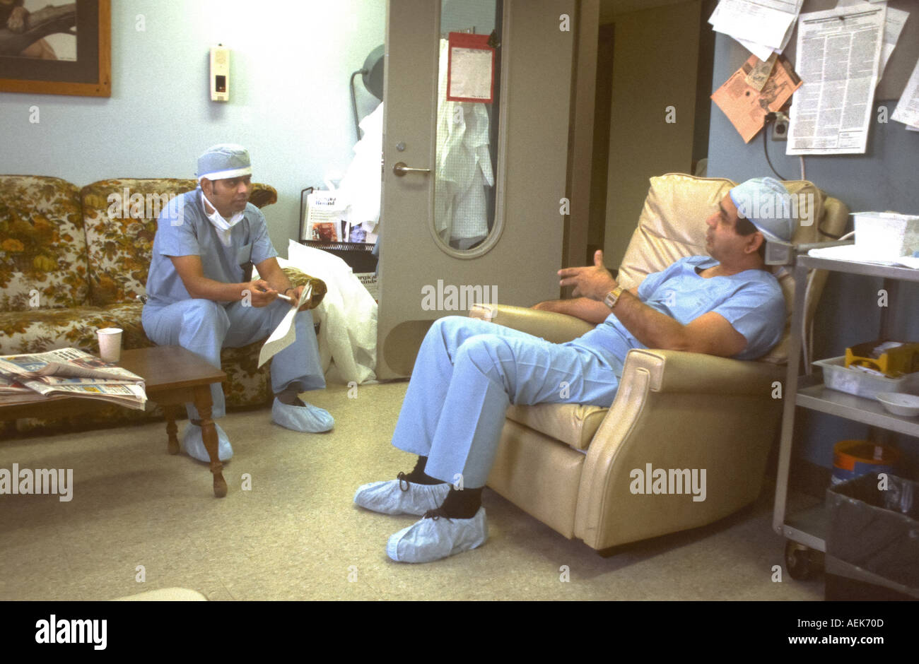 Two 2 doctors relax in a hospital staff room and discuss a previous ...