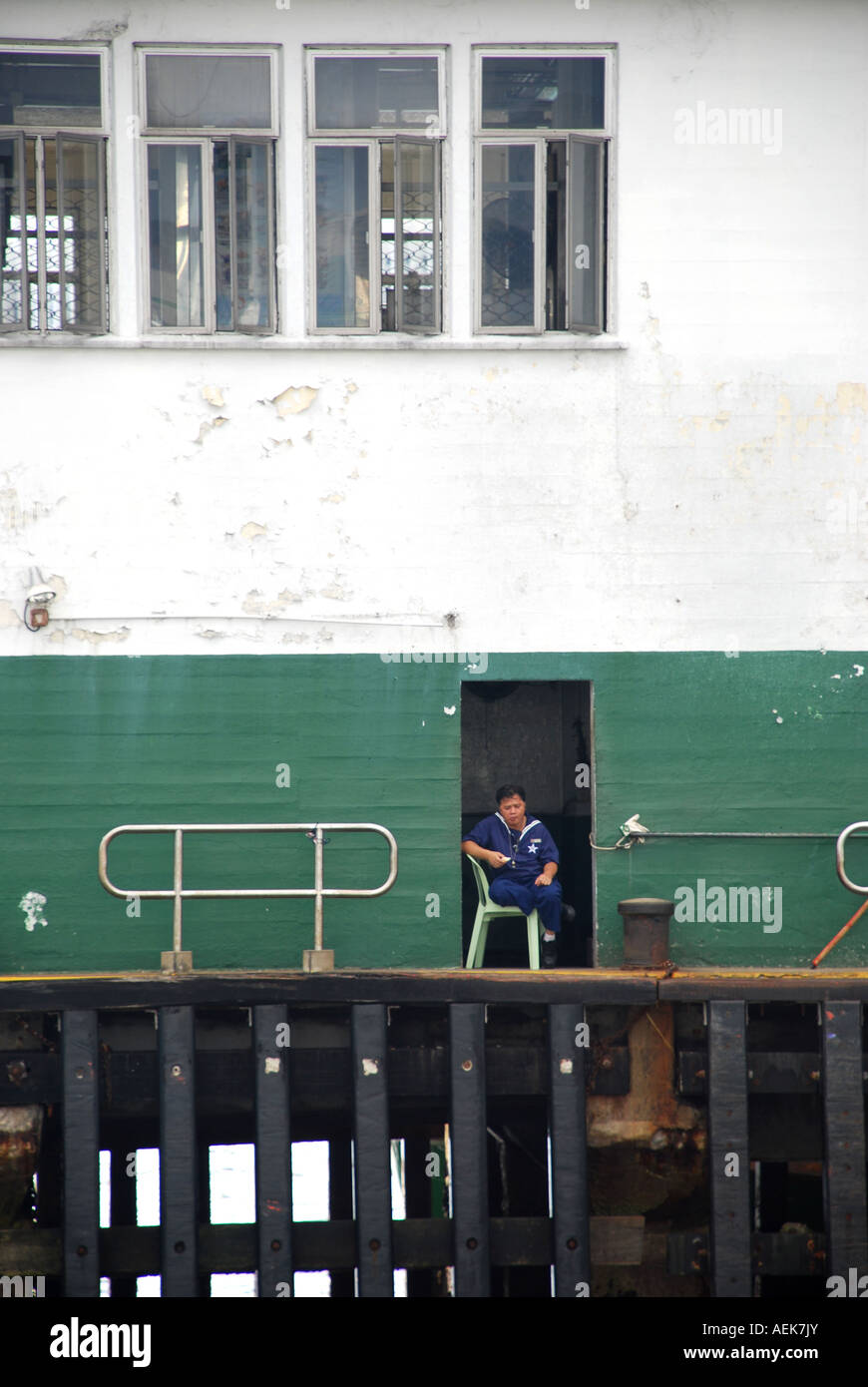 STAR FERRY WORKER TAKING A BREAK AT THE KOWLOON SIDE TERMINAL HONG KONG ...
