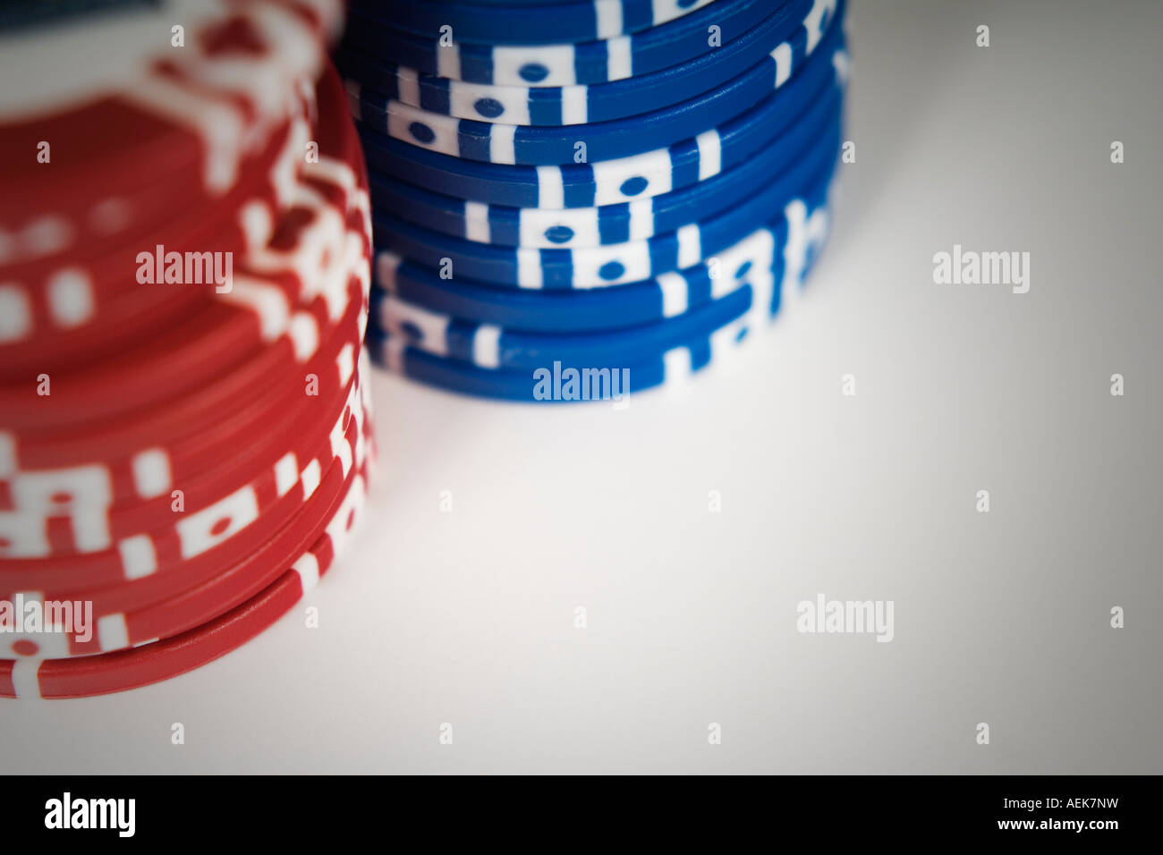 Red and blue gaming chips on a white surface Stock Photo - Alamy