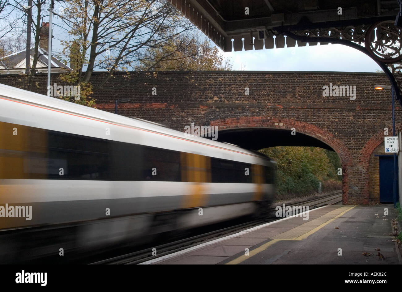 Train entering bridge tunnel at suburban station, Kent, England Stock ...