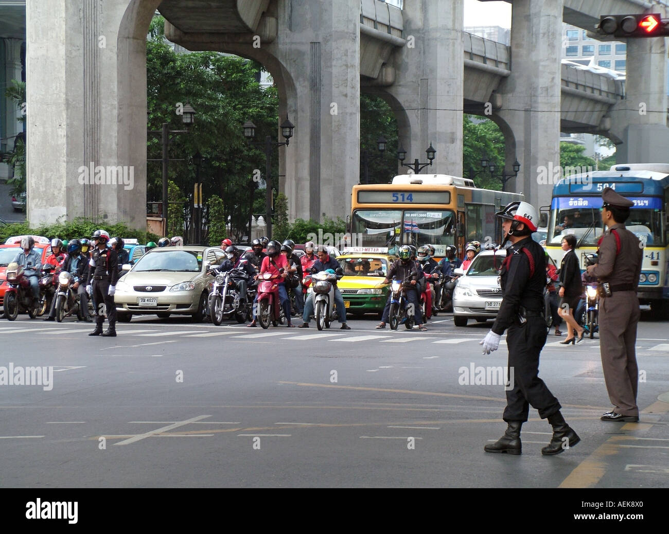 motorcyclists cars and scooter riders at traffic light central Bangkok ...