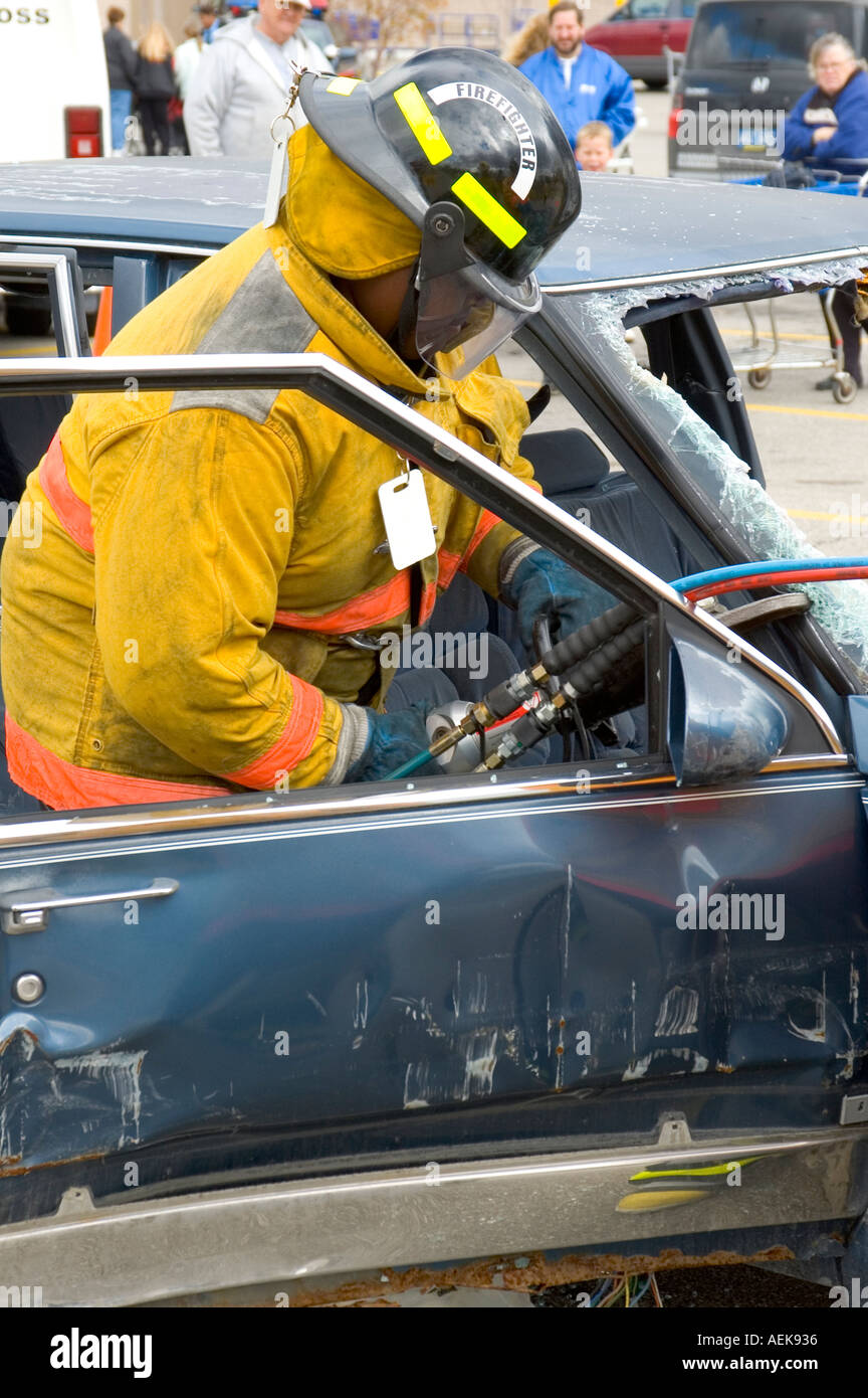 Fireman works with the jaws of life to extract victim from automobile ...